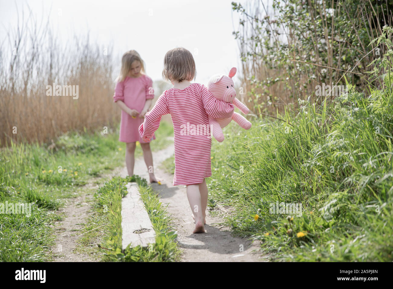 Two girls walking in meadow Stock Photo - Alamy