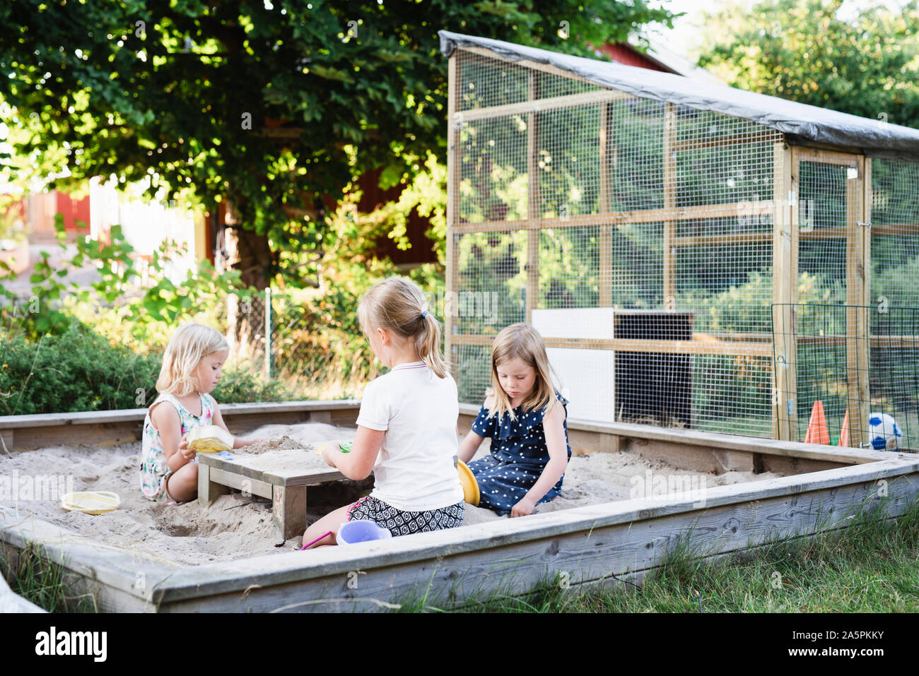 Girls playing in sandpit Stock Photo - Alamy
