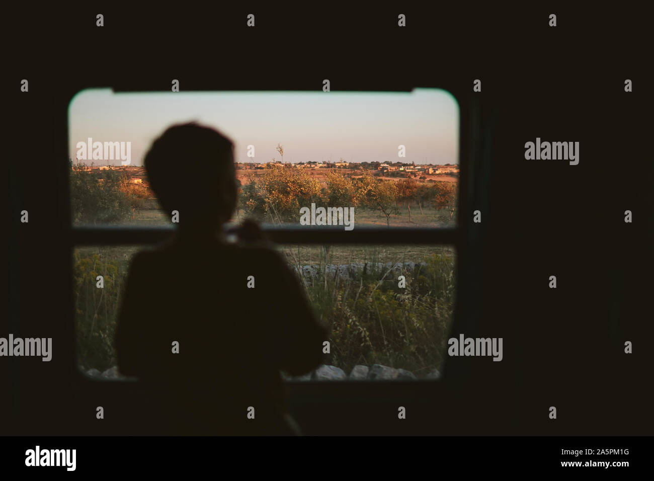 Silhouette of boy looking through train window Stock Photo - Alamy
