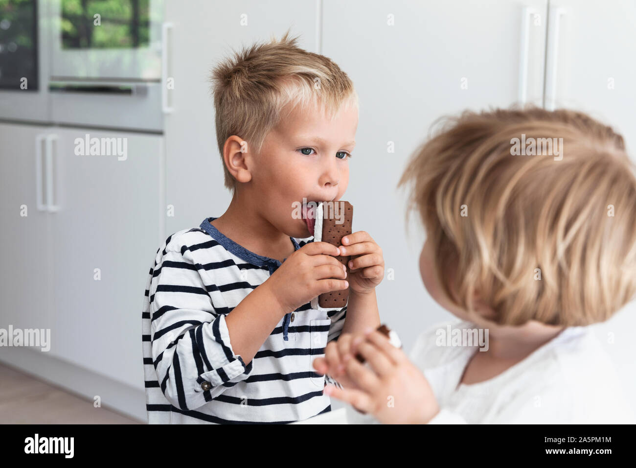 Boy eating biscuit Stock Photo - Alamy
