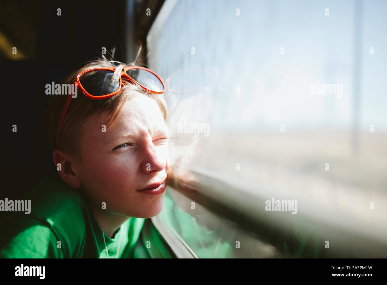 Boy looking through train window Stock Photo - Alamy