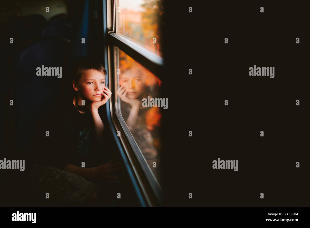 Boy looking through train window Stock Photo - Alamy