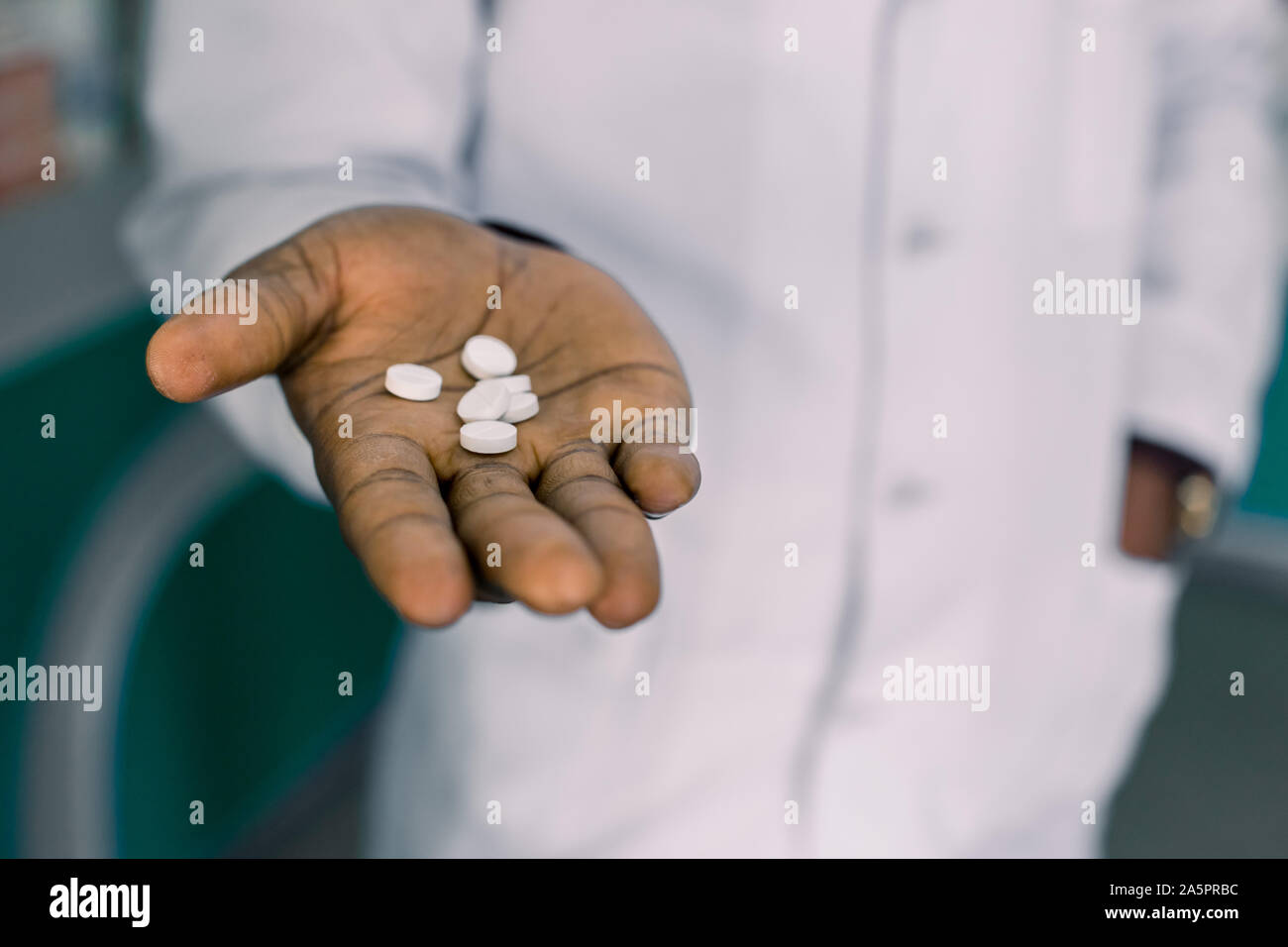 African doctor or pharmacist holding pill, male hand with medication ...