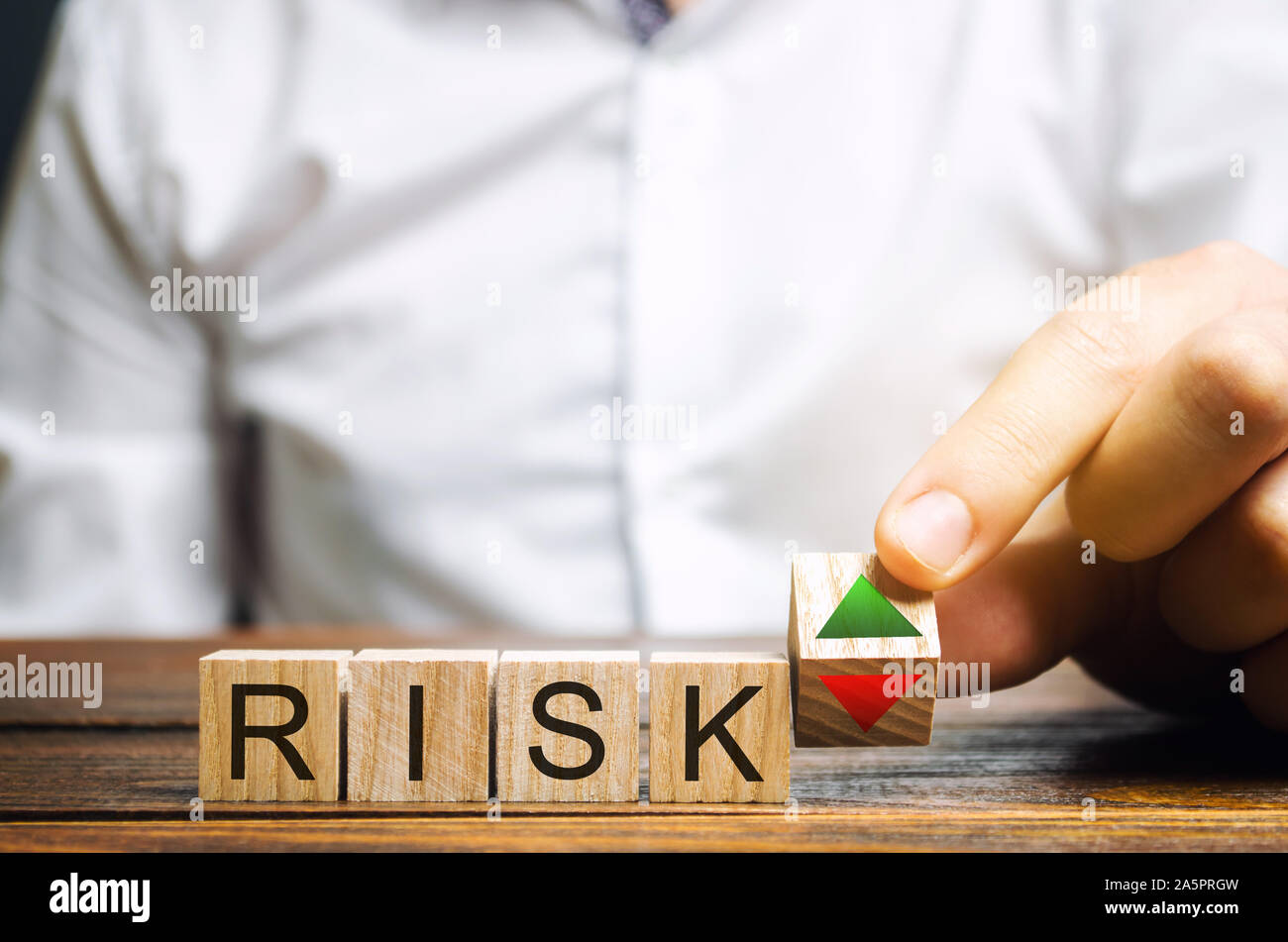 Businessman puts wooden blocks with the word Risk and up and down ...