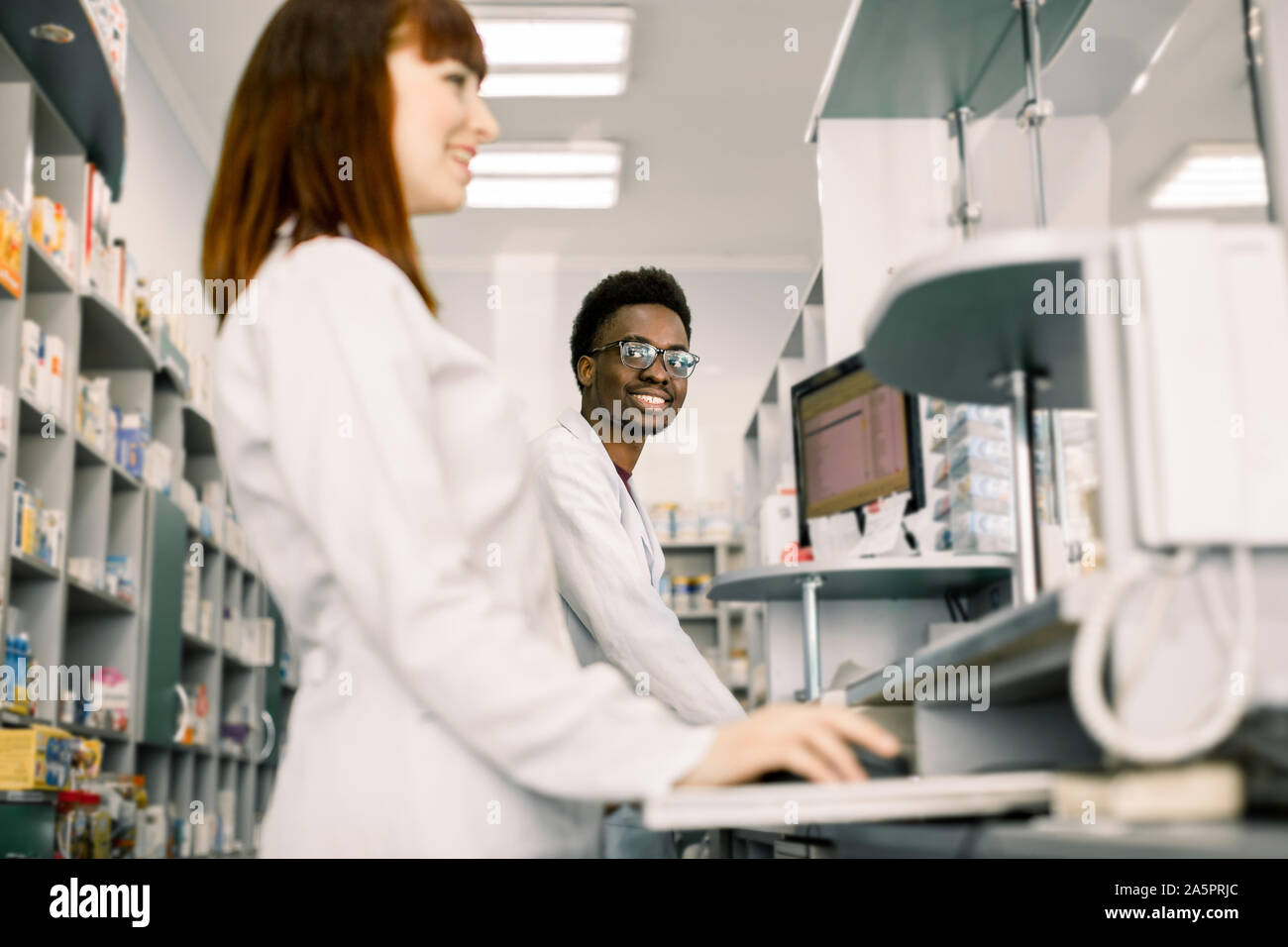 Two pharmacists man and woman checking information about medicines on ...