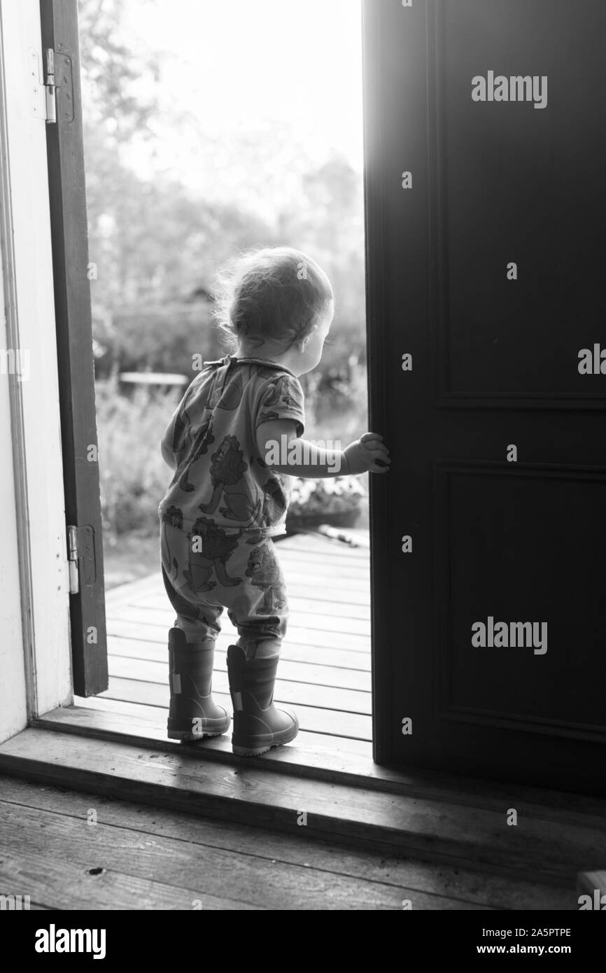 Toddler girl standing at door step Stock Photo - Alamy