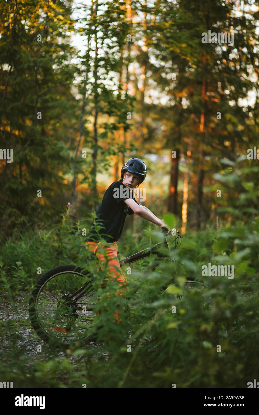 Boy riding bike in forest Stock Photo - Alamy