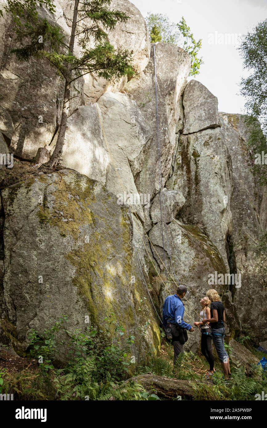 Three people preparing for rock climbing Stock Photo - Alamy