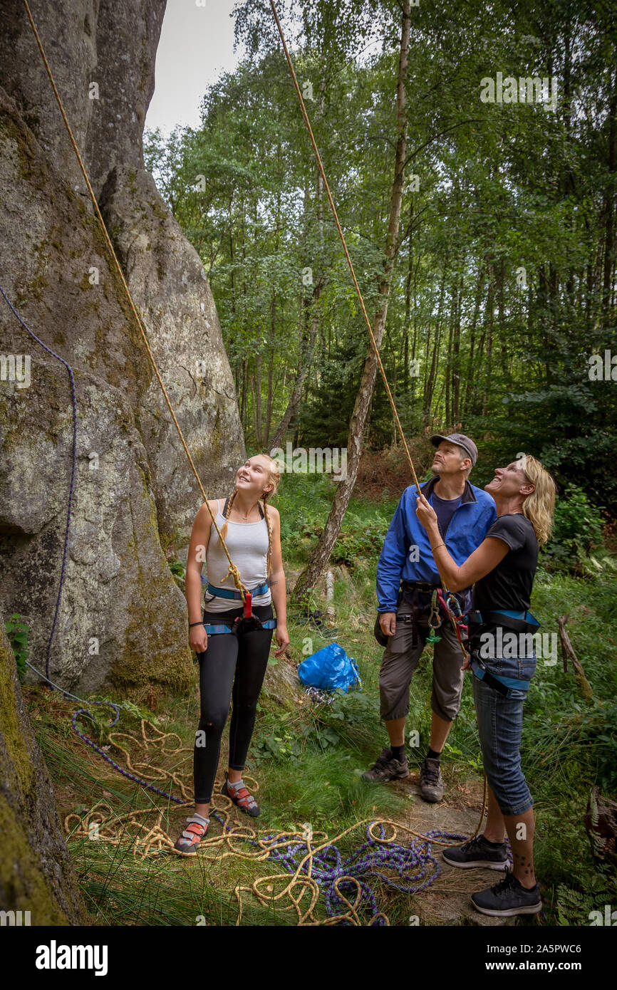 Three people preparing for rock climbing Stock Photo - Alamy