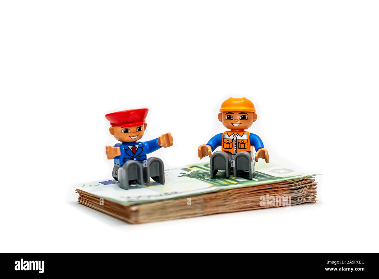 Minifigure toy worker model standing of a pilo of euro banknote, money ...