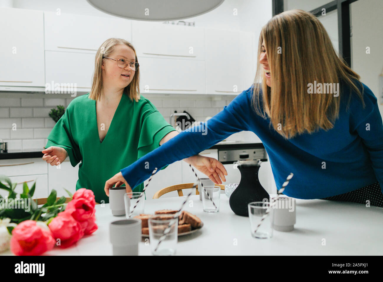 Mother and teenage girl preparing table Stock Photo - Alamy