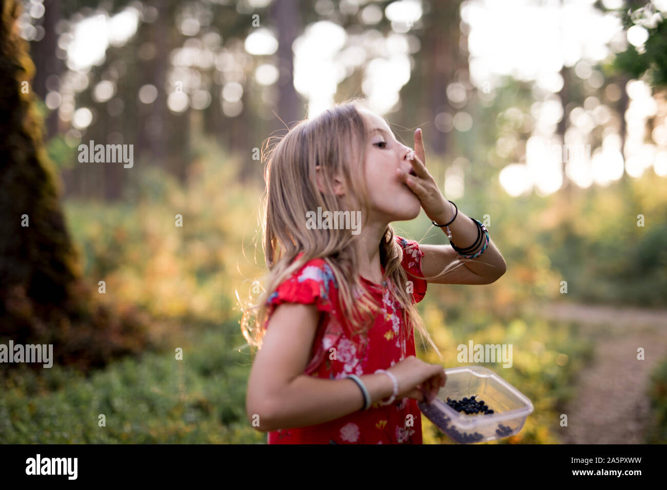 Girl eating blueberries Stock Photo - Alamy