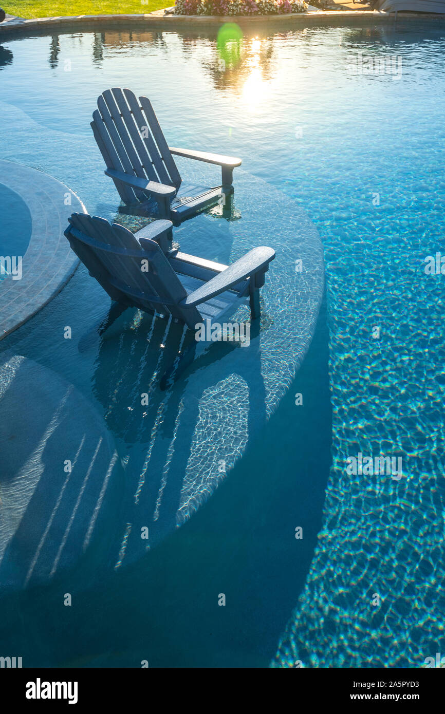 Two Adirondack Chairs in the swimming pool Stock Photo - Alamy