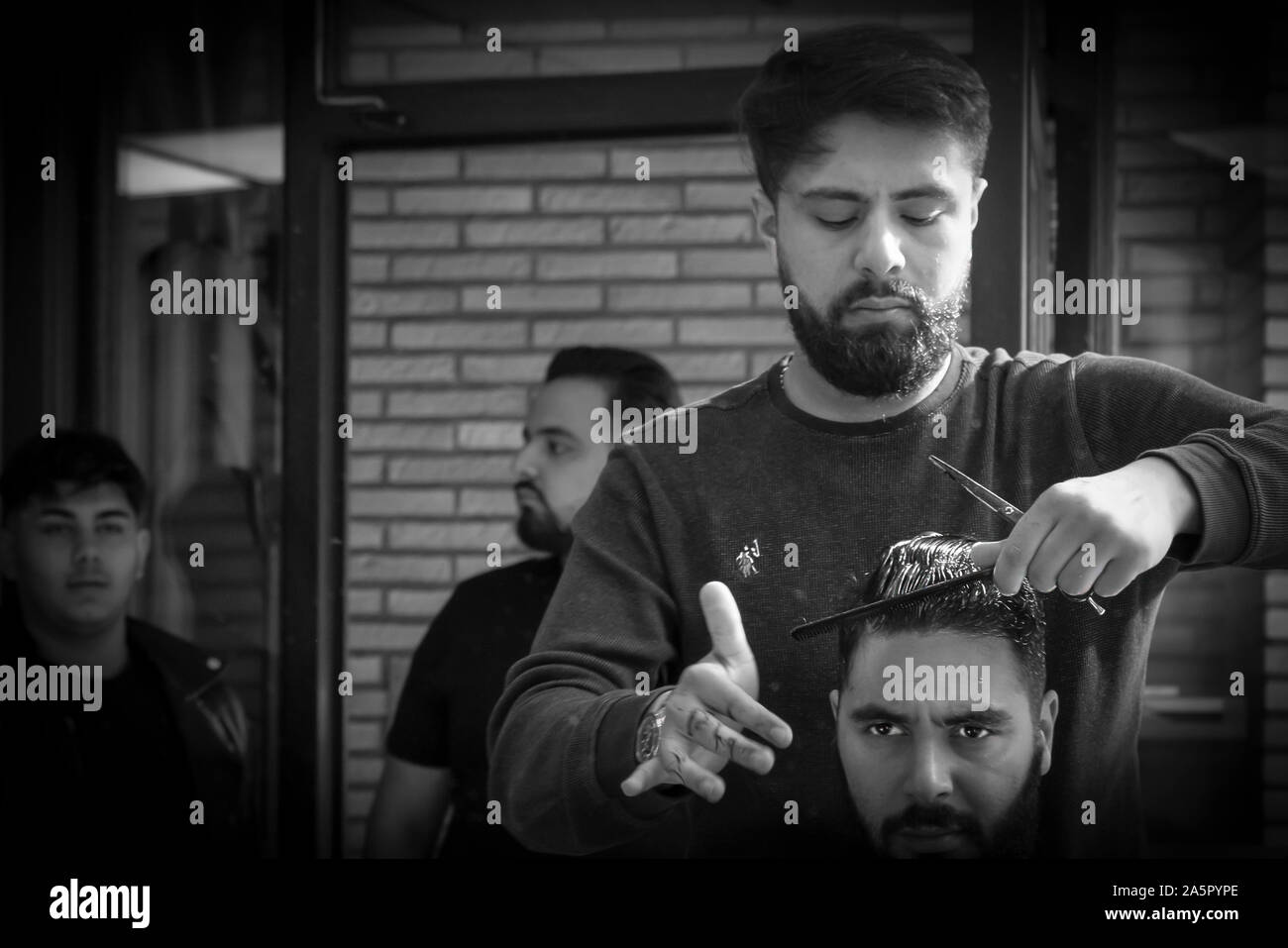 Brussels, Belgium - October 4 2019: Man getting haircut in a busy hair ...