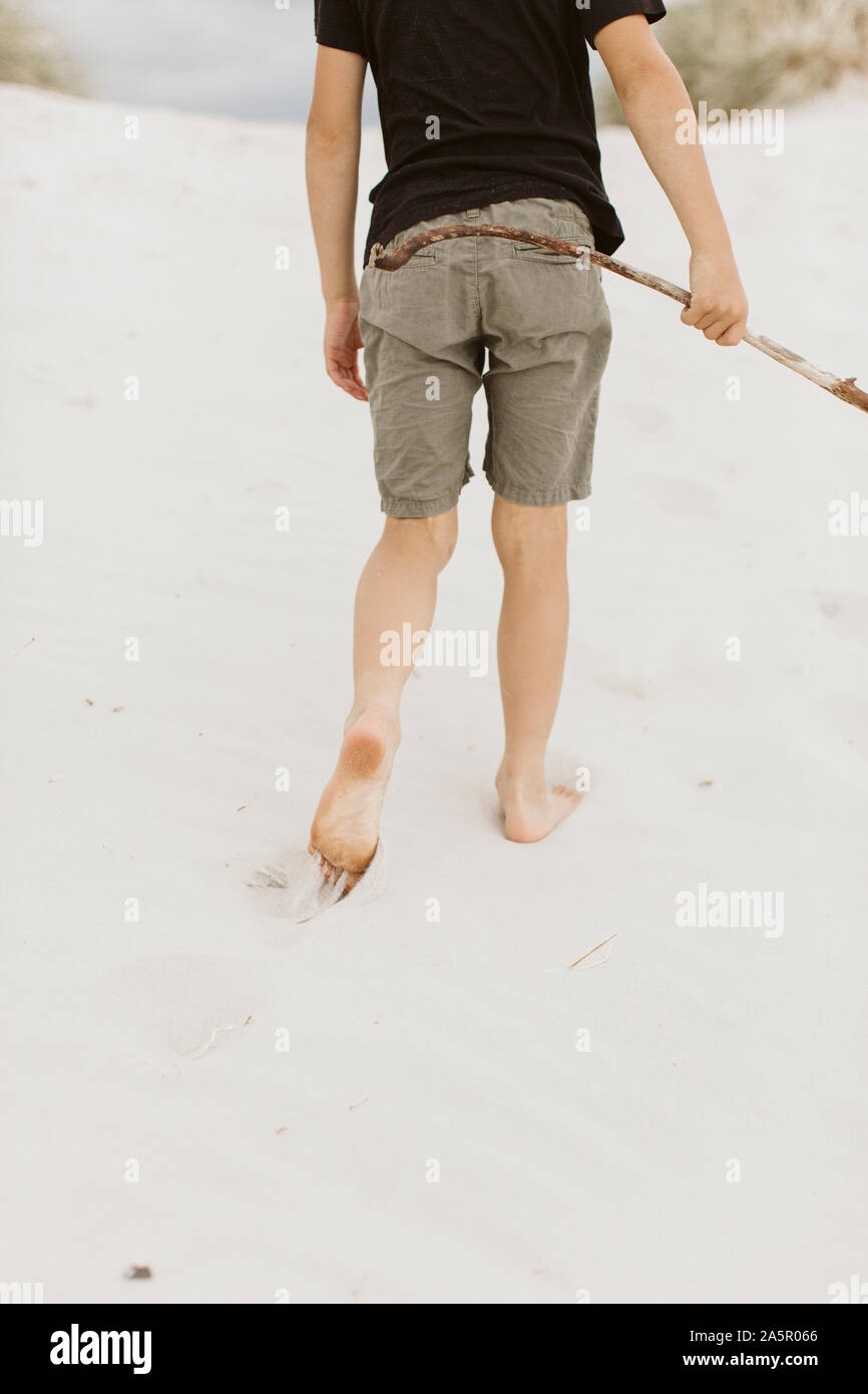 Boy walking on sand Stock Photo - Alamy
