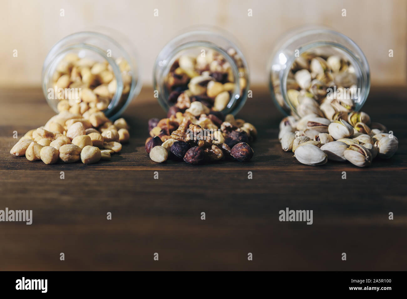 front view of three glass jars with varied nuts and mixed dried fruits ...