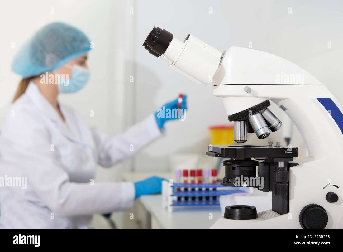 Woman researcher in laboratory testing samples on white blood cells ...