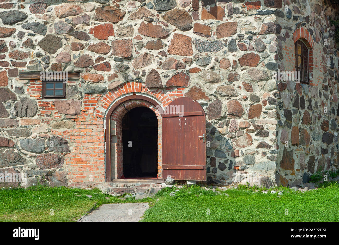 Wall of old castle with opened door Stock Photo - Alamy
