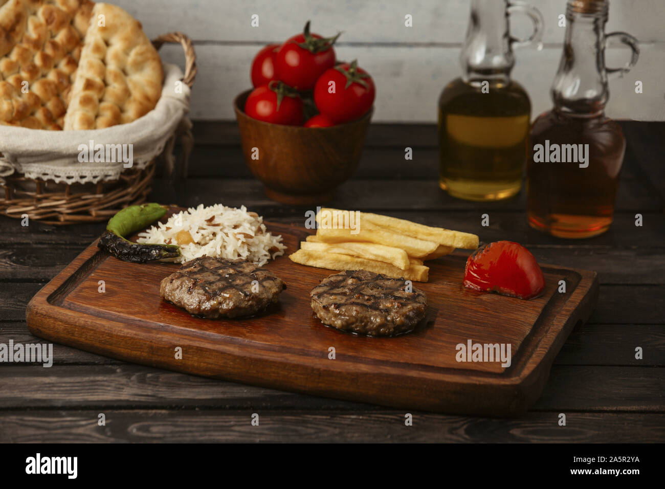 grilled beef patties served with rice, fries, grilled tomato and pepper ...