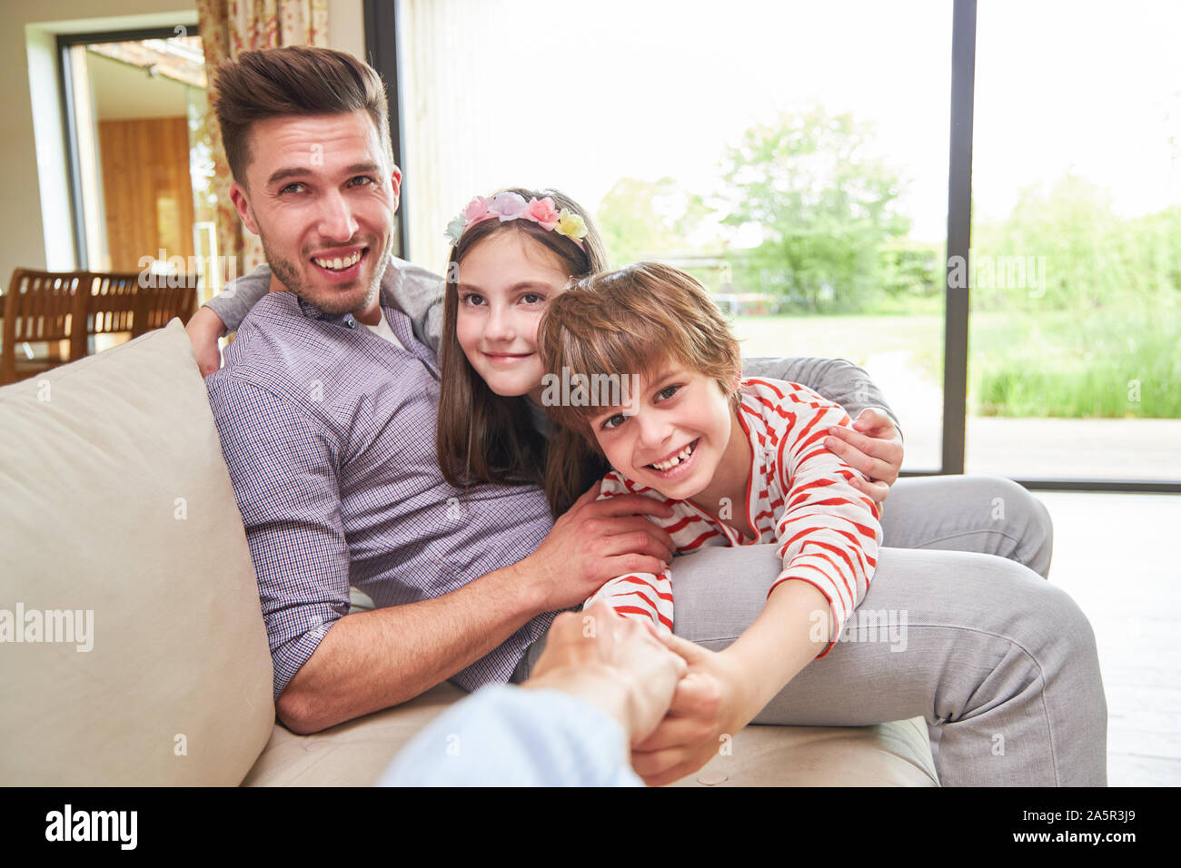 Happy father with two kids in the living room on the sofa at home Stock ...