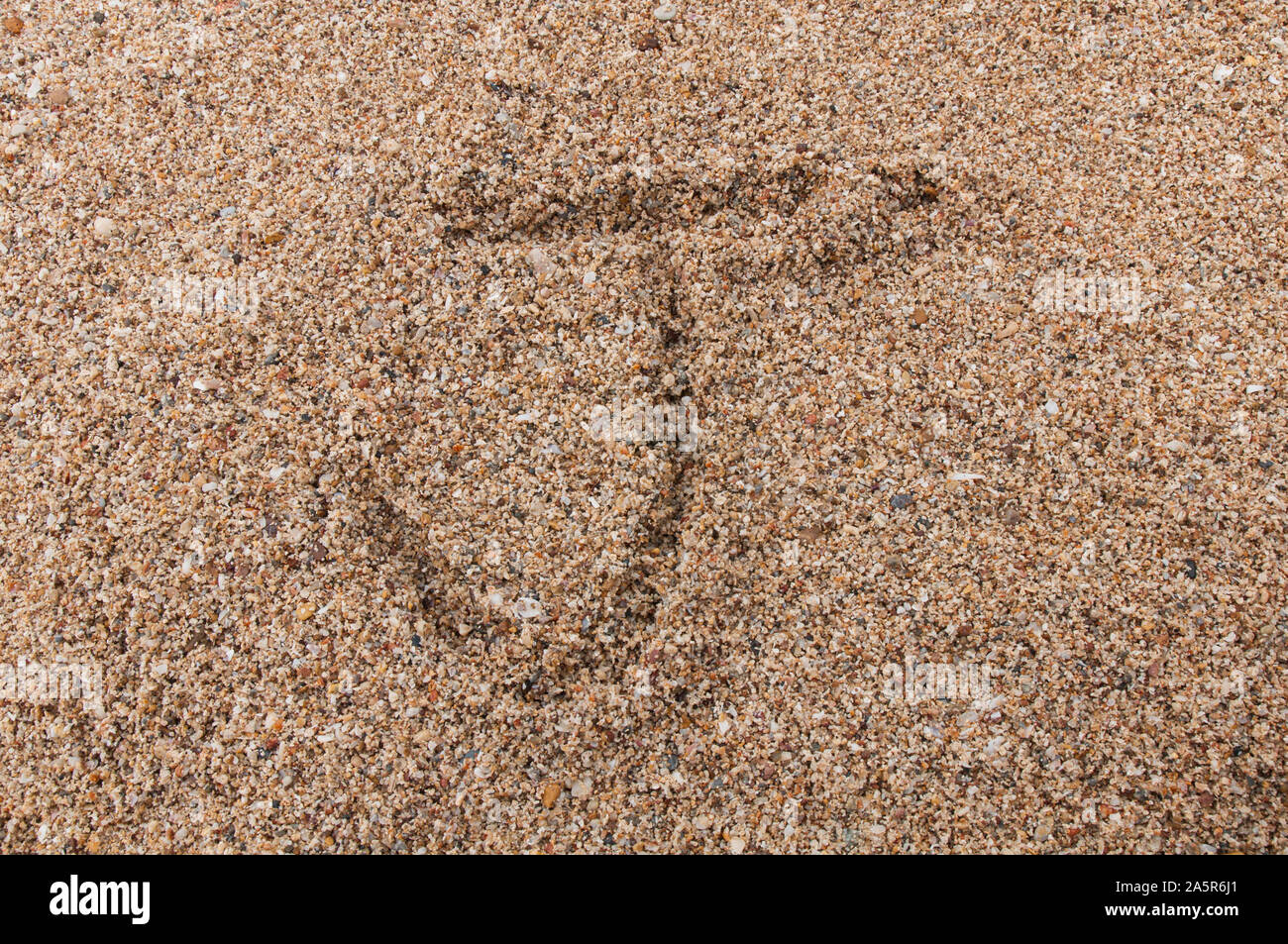 Character J of the alphabet writing on the sand Stock Photo - Alamy
