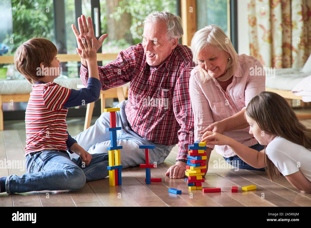 Grandpa and grandchildren give themselves a high five when playing with ...