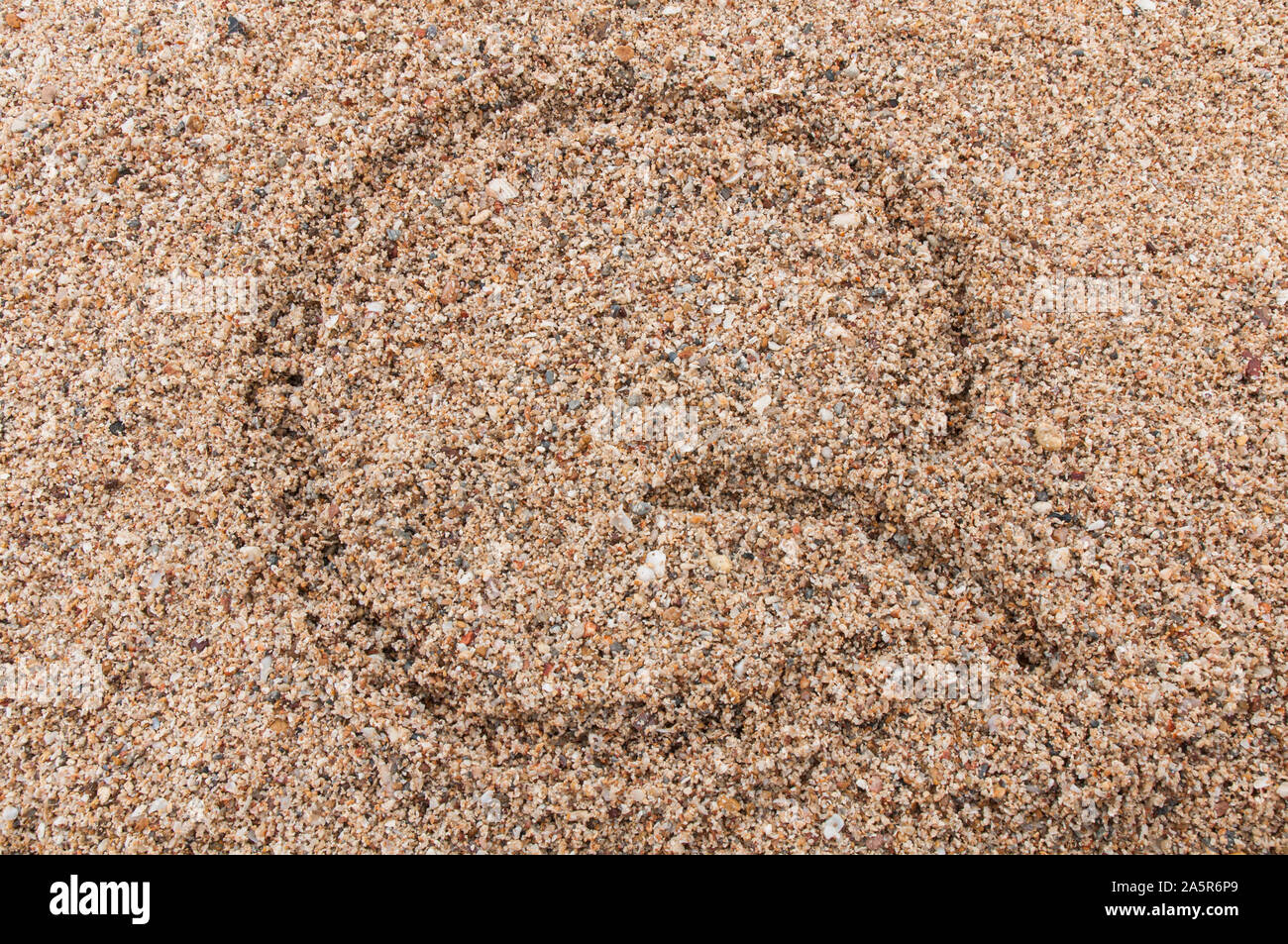 Character Q of the alphabet writing on the sand Stock Photo - Alamy