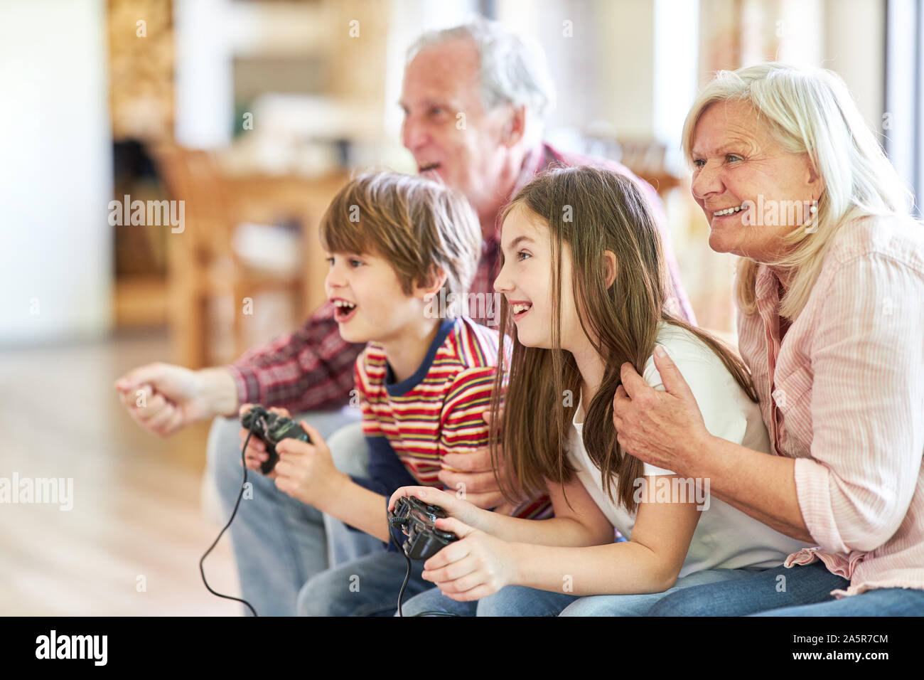 Family with grandparents playing video game Gaming in front of Smart TV ...