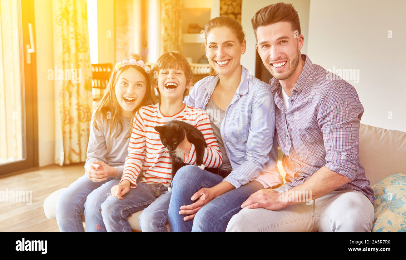 Happy family with two children and cat as a pet in the living room ...