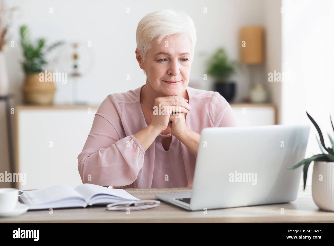 Old woman reading article online, using laptop Stock Photo - Alamy