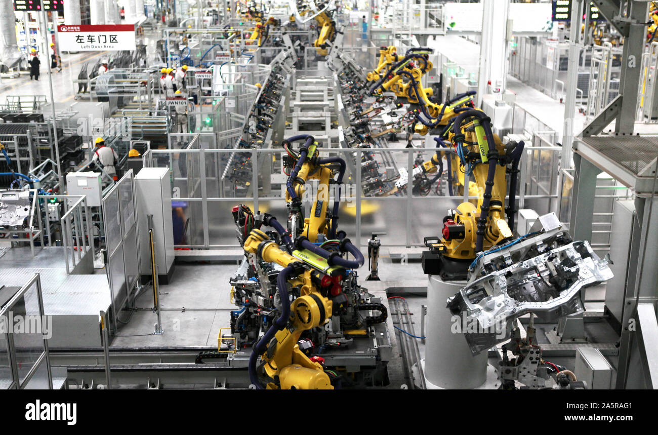 Robot arms weld car parts on the assembly line at the auto plant of ...