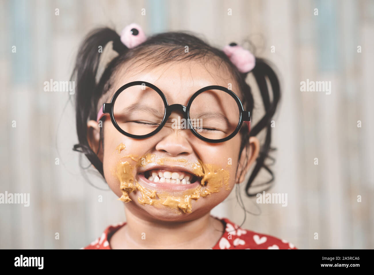 cute little girl with mouth smeared with peanut butter. Concept of ...