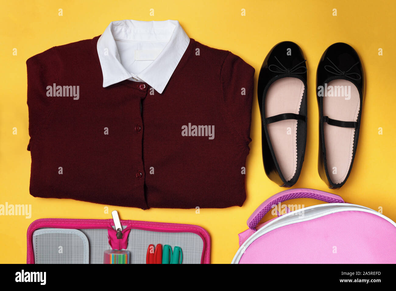 Top view of the composition of school clothes for children on a yellow ...