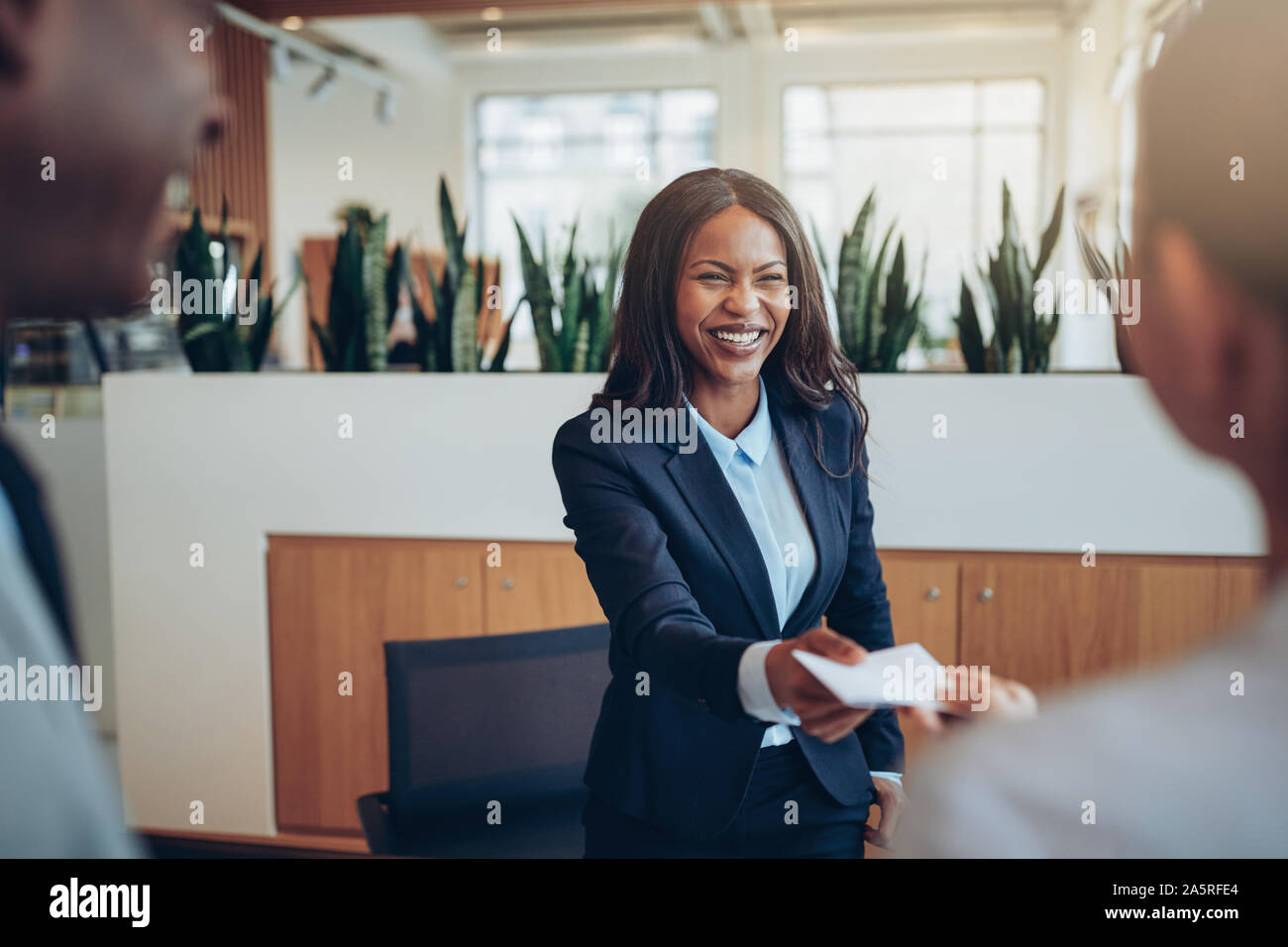Smiling African American concierge working behind a hotel counter ...