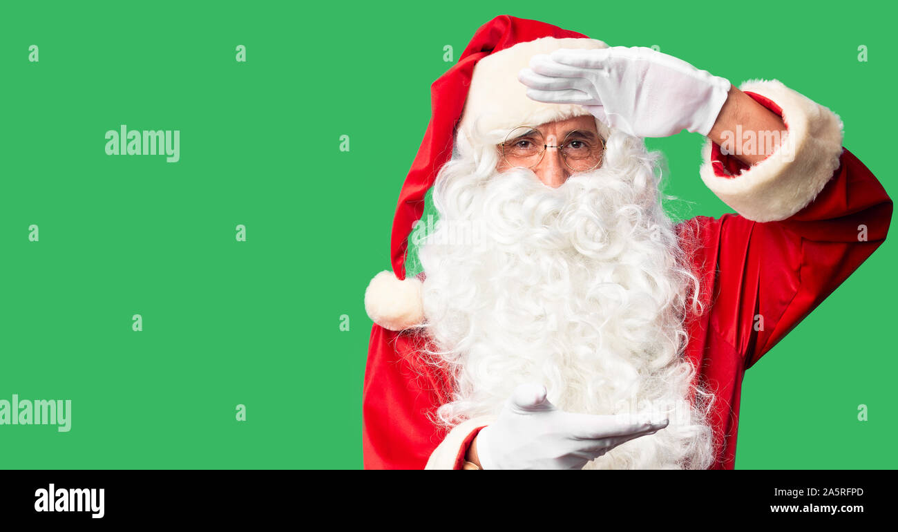 Middle age handsome man wearing Santa Claus costume and beard standing ...