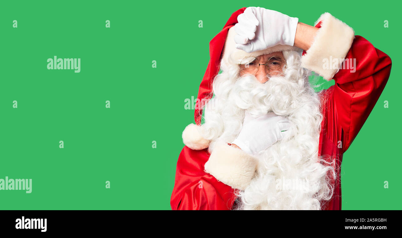 Middle age handsome man wearing Santa Claus costume and beard standing ...
