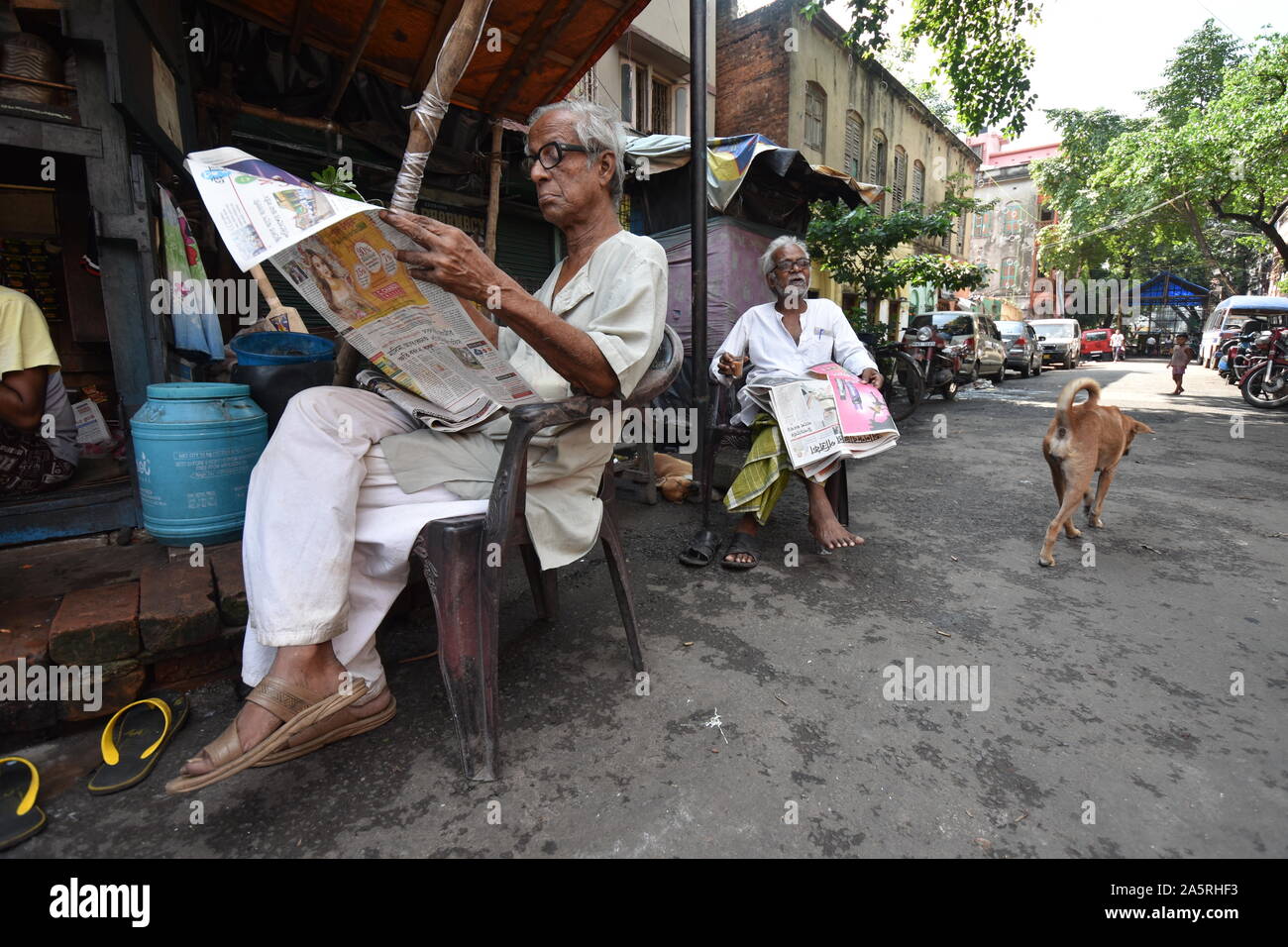 Old men reading newspaper at a tea stall of the Shyambazar Street ...