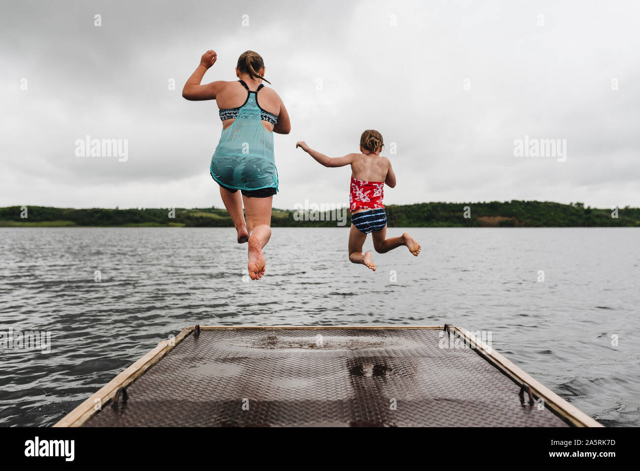 Girl jumping off dock lake hi-res stock photography and images - Alamy