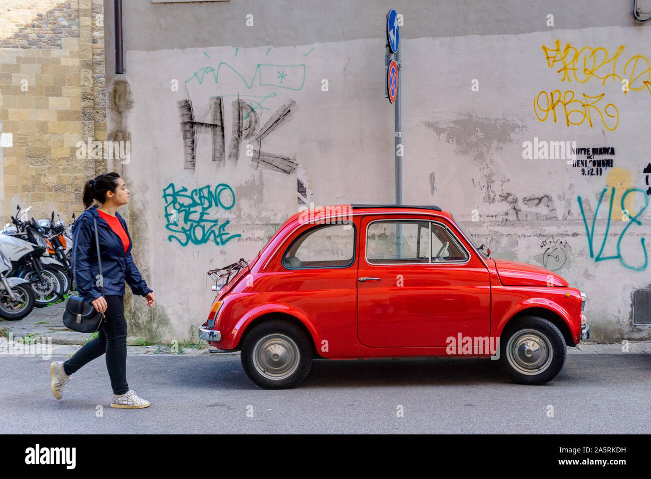red fiat 500 parked in front of graffiti wall pisa italy young woman ...