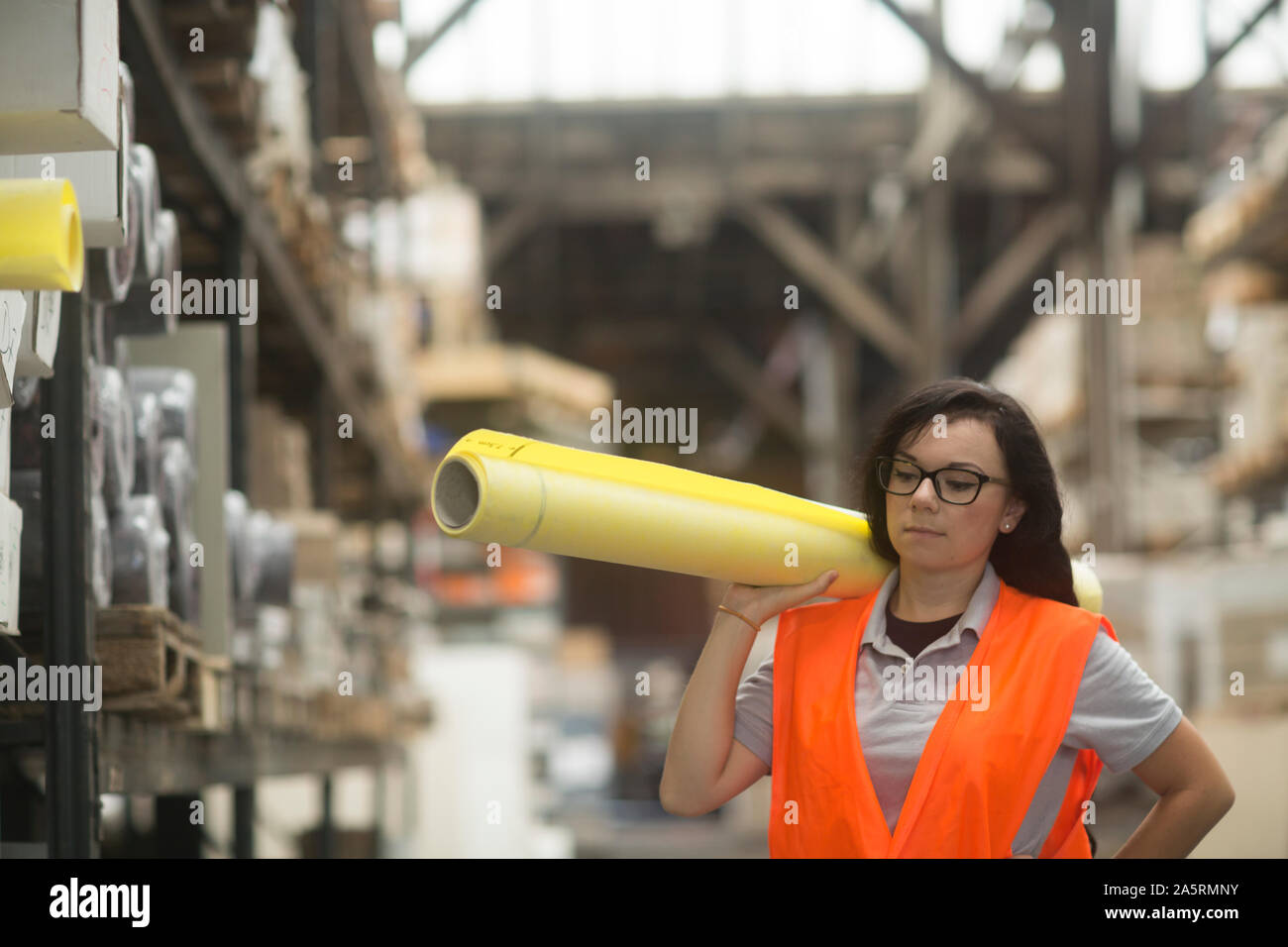 storekeeper female in a warehouse carrying a product Stock Photo - Alamy