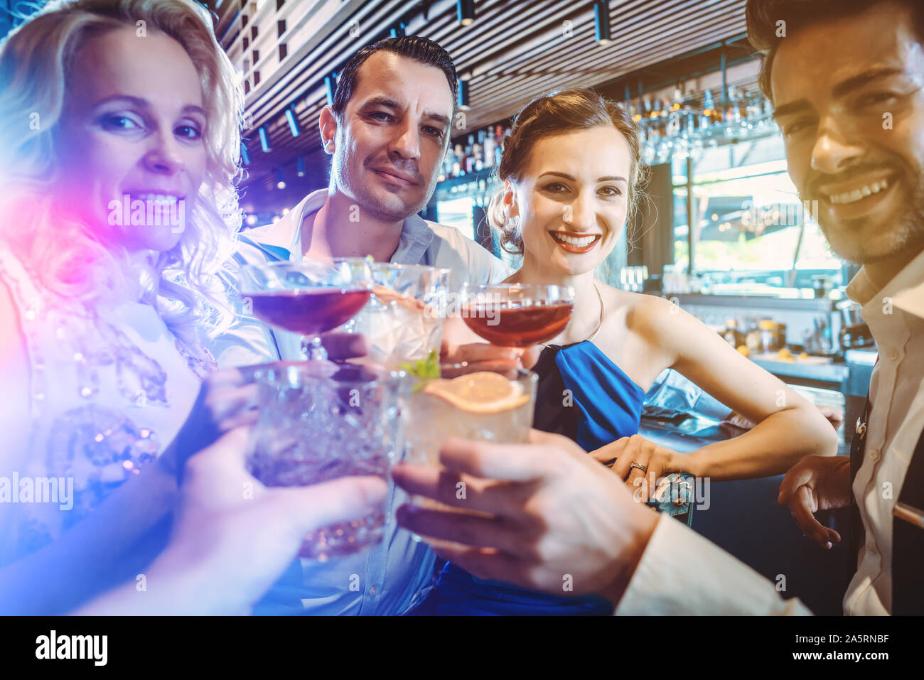 Four friends in a bar Stock Photo - Alamy