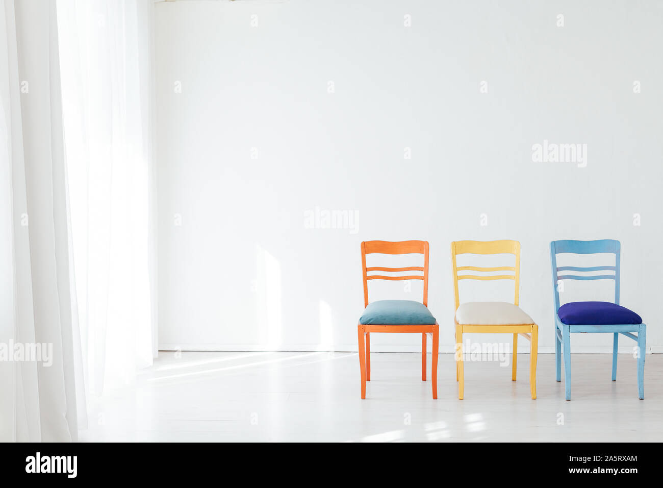 multicolored chairs in the interior of an empty white room Stock Photo ...
