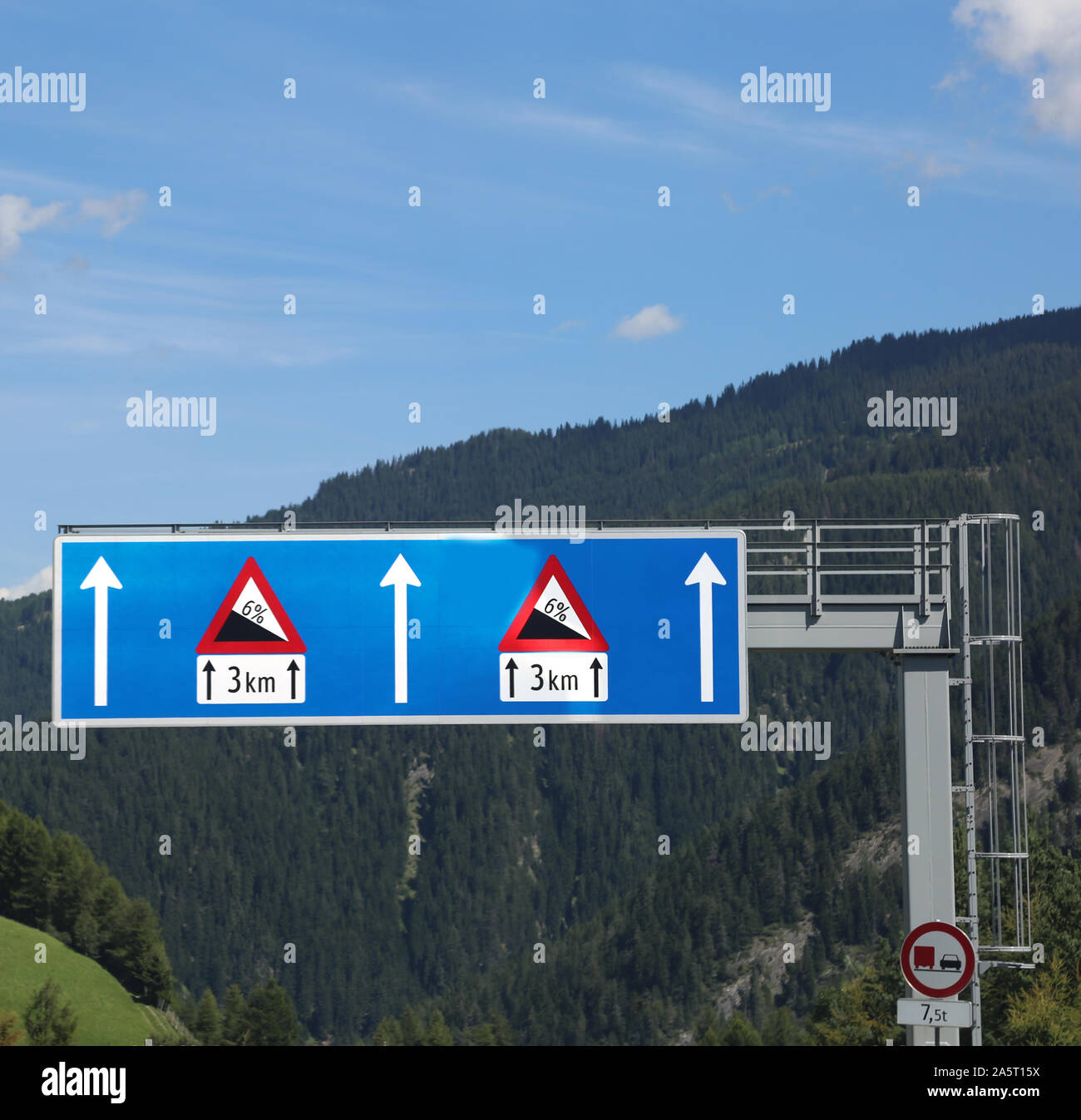 two big road signs with very steep road and danger of overheating of ...