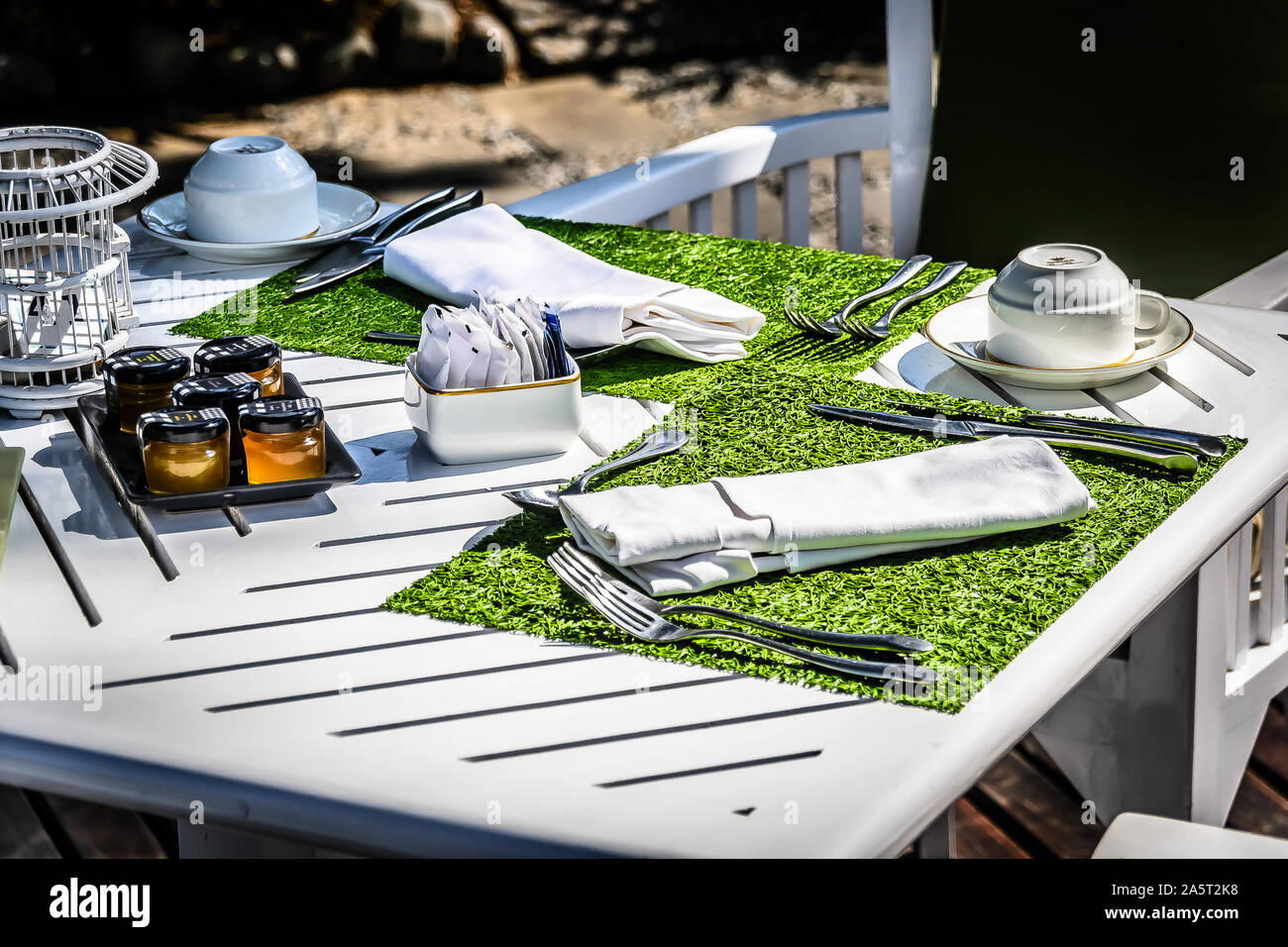 laid breakfast table with placemats and white linen napkins and cutlery ...