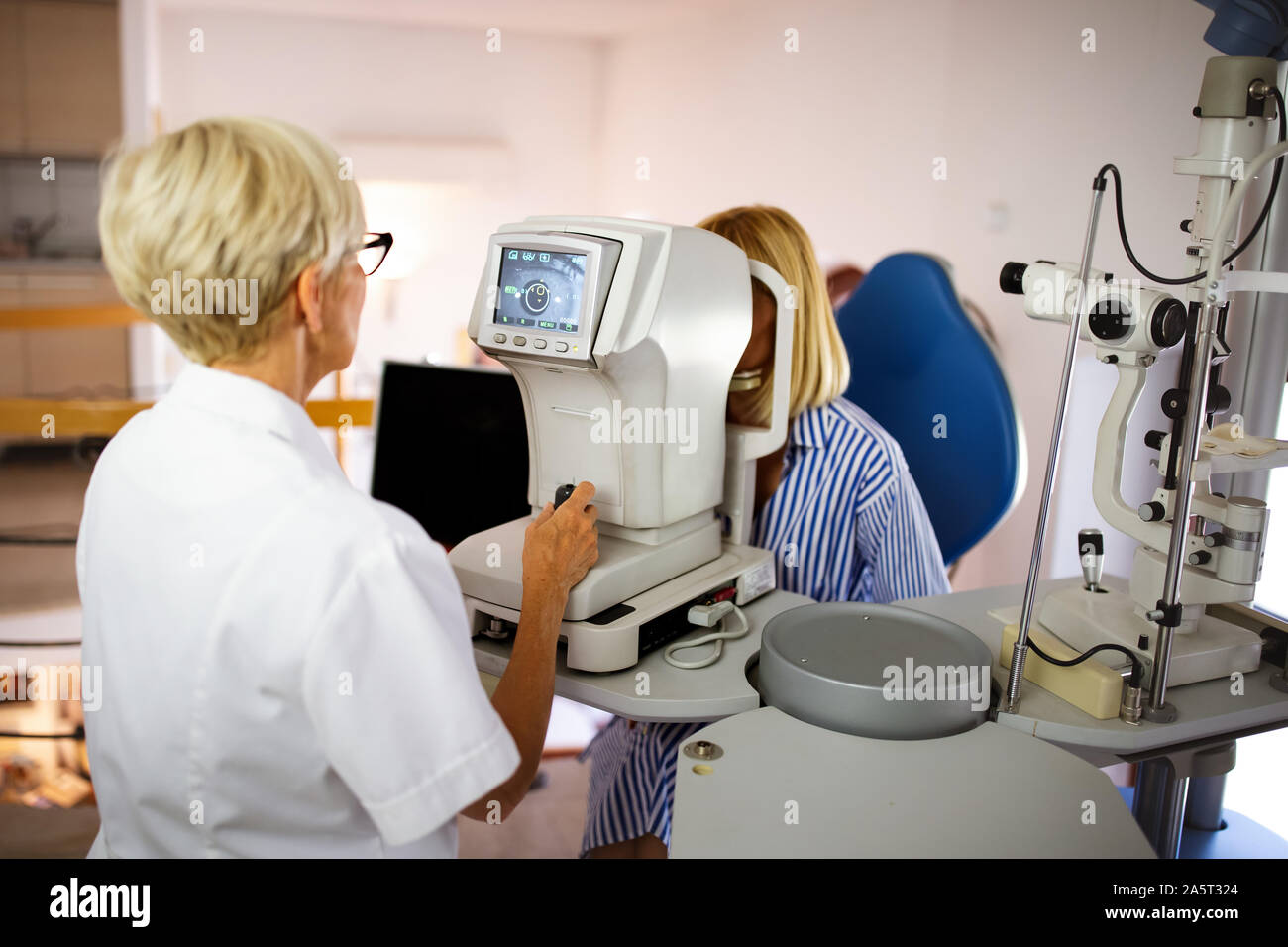 Women looking at eye test machine in ophthalmology clinic Stock Photo ...