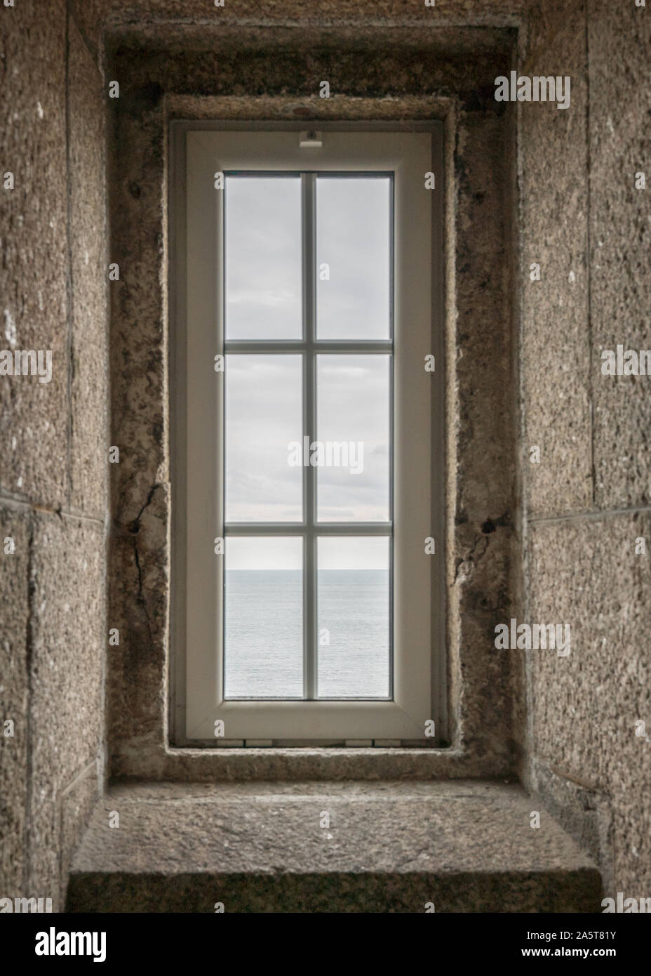 A verticalview of the ocean through a lighthouse window in the stone ...