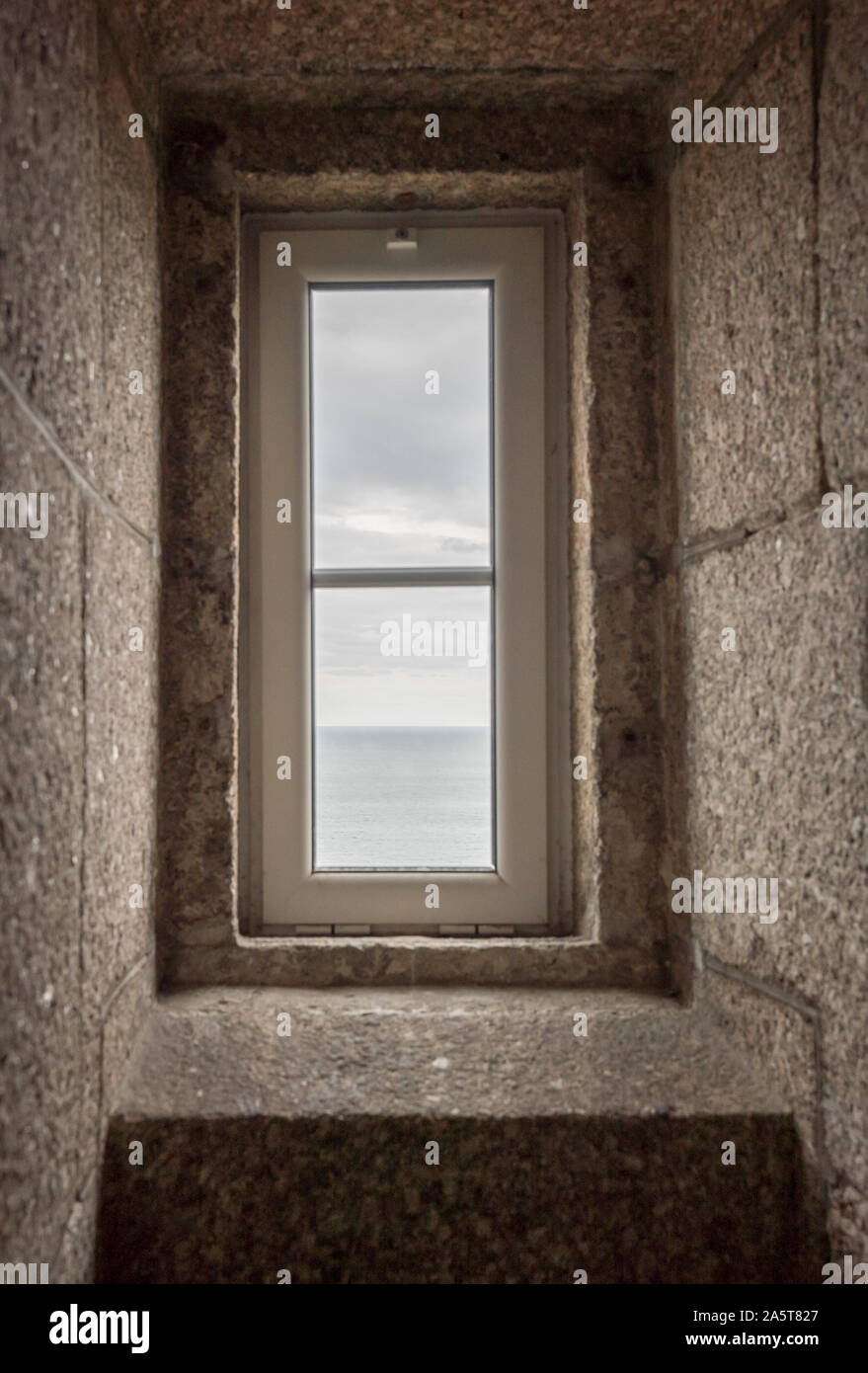 A verticalview of the ocean through a lighthouse window in the stone ...