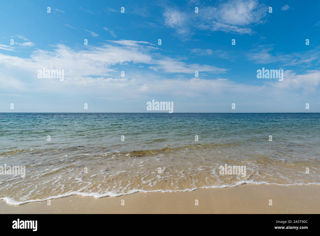 empty tropical beach with gentle waves and a great view over the calm ...