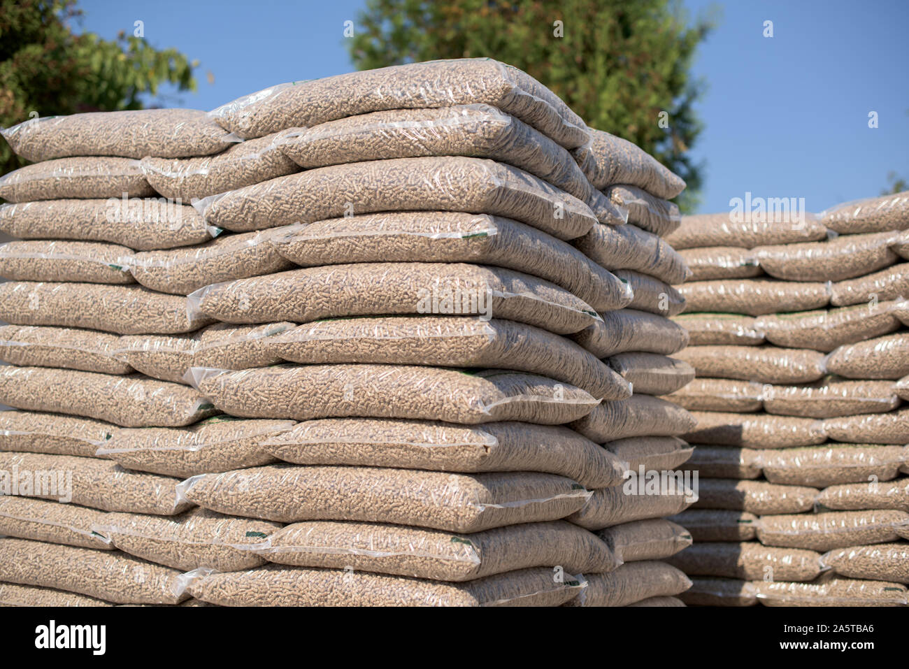 Piles of plastik bags full with wooden pellets arranged in rows and ...