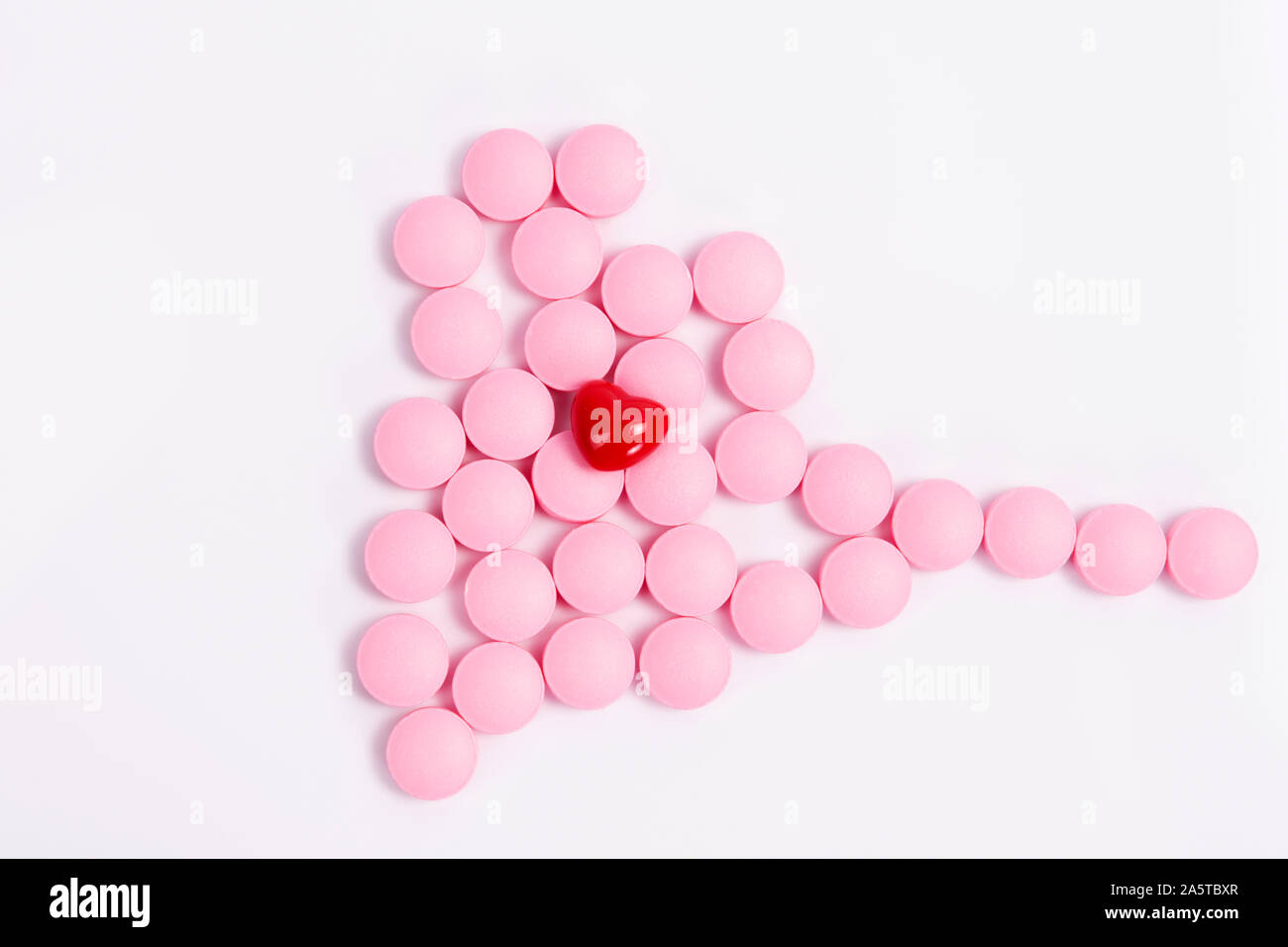 Pink pills on a white background with a red heart. Heart pills Stock ...